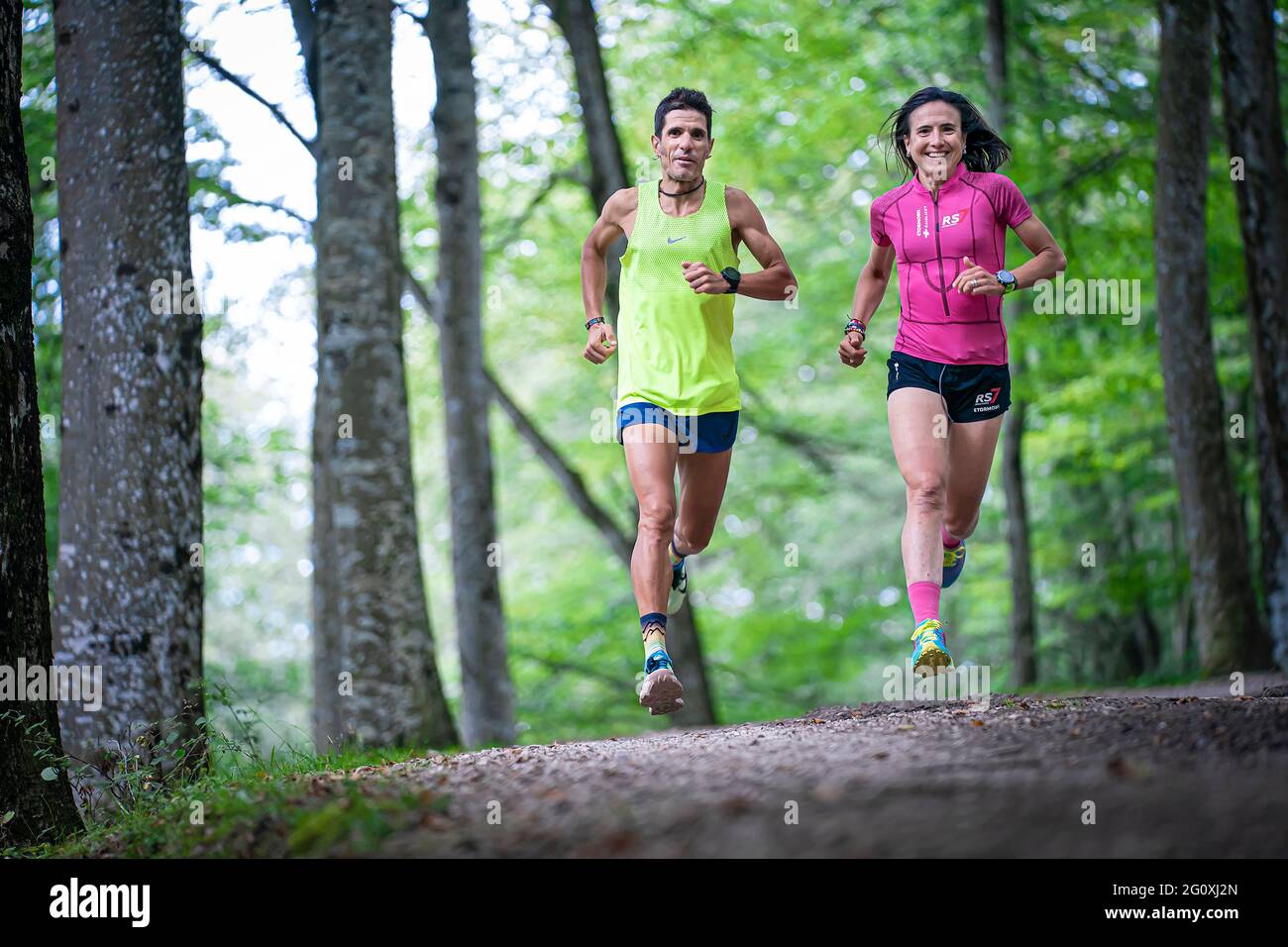 Group of runners running on a trail along beautiful mountain roads ...