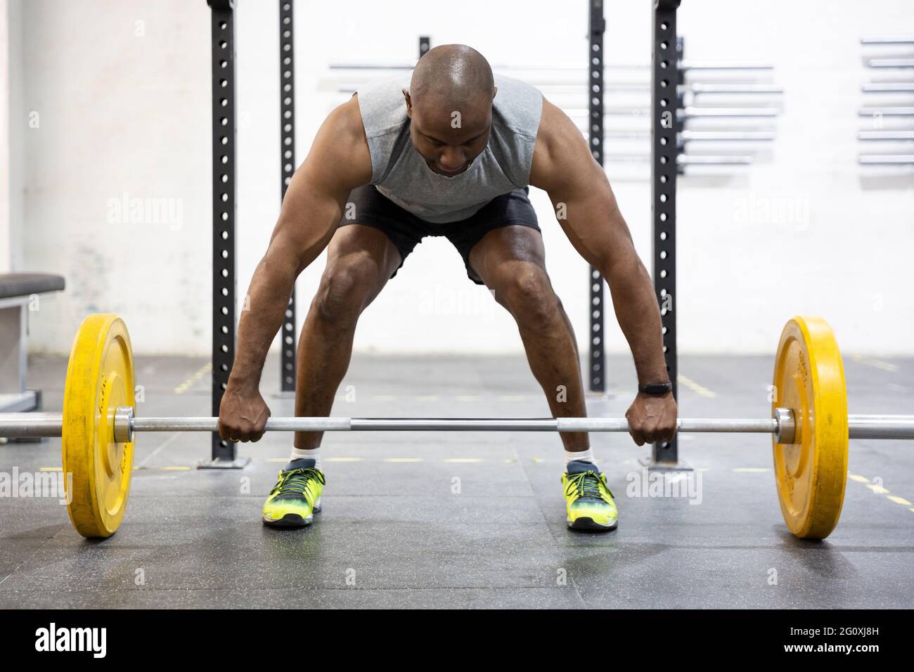 Front view of strong African American male athlete preparing for weight ...