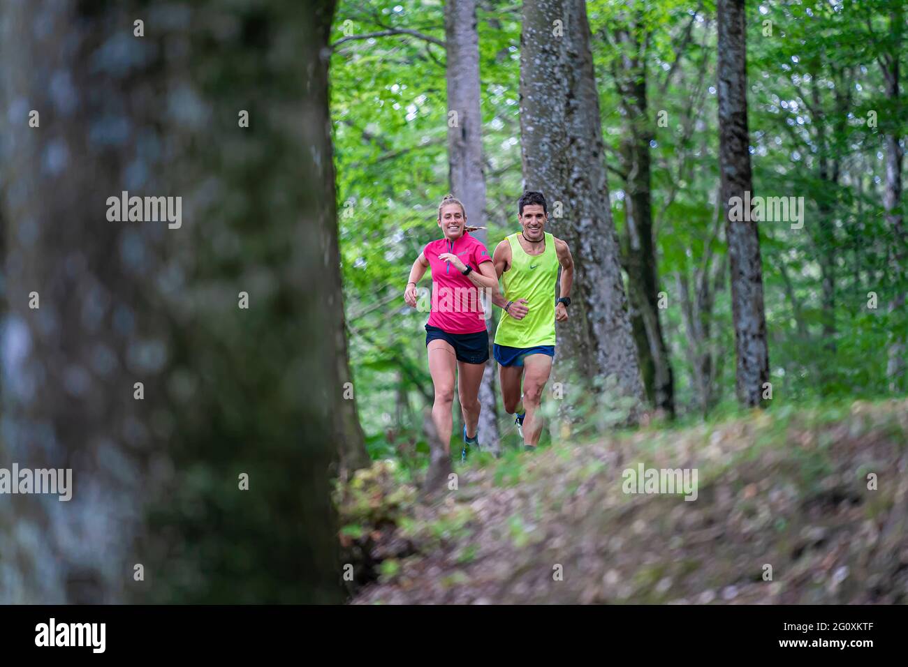 Group of runners running on a trail along beautiful mountain roads ...