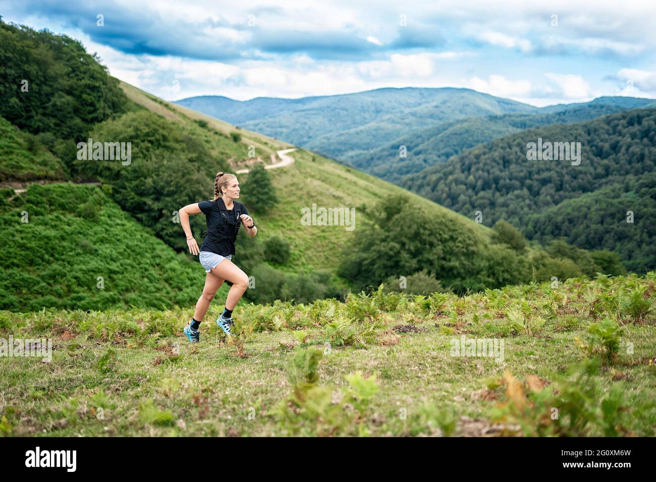 Group of runners running on a trail along beautiful mountain roads ...