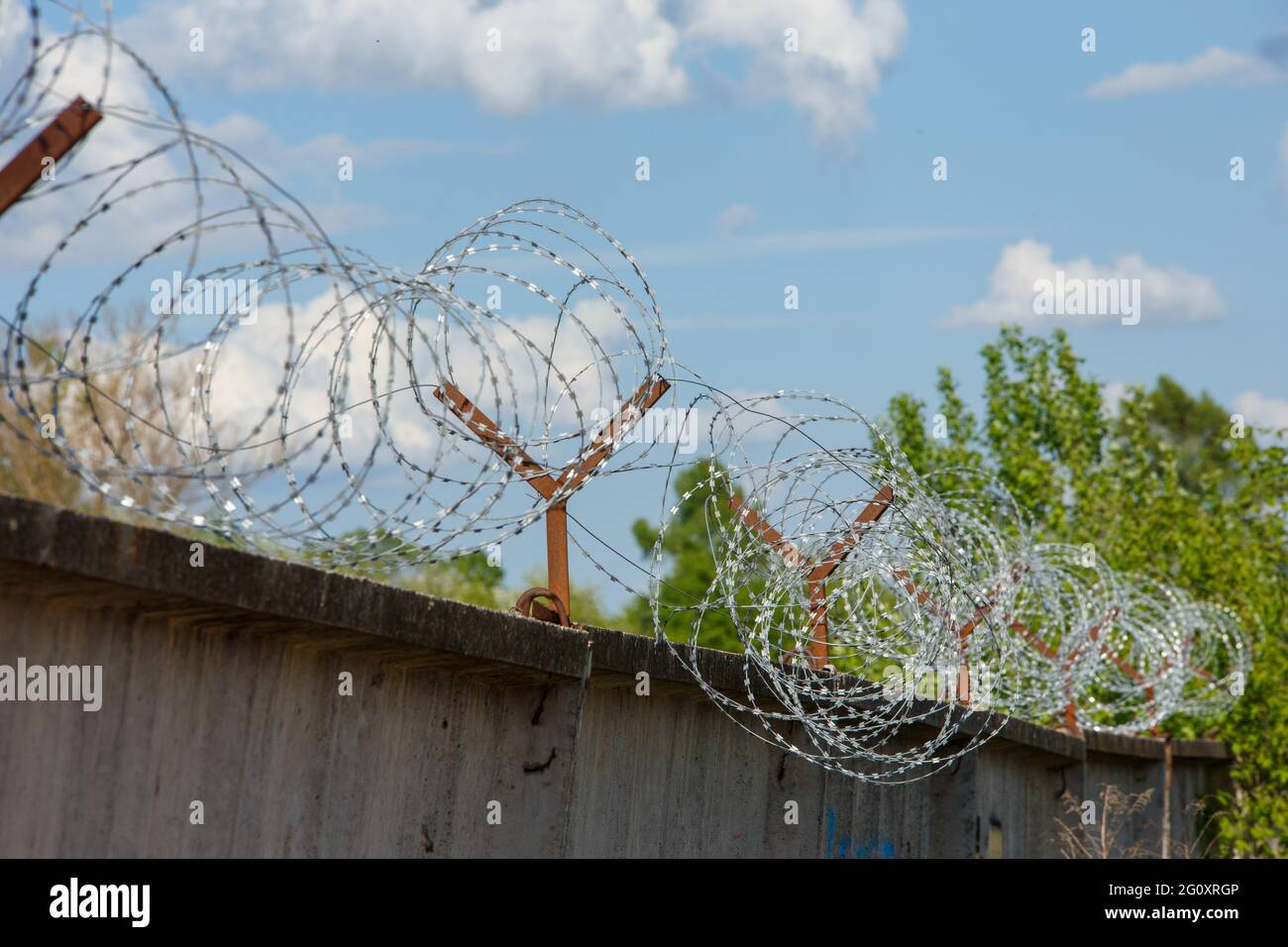 close-up view of barb wire over concrete fence Stock Photo - Alamy