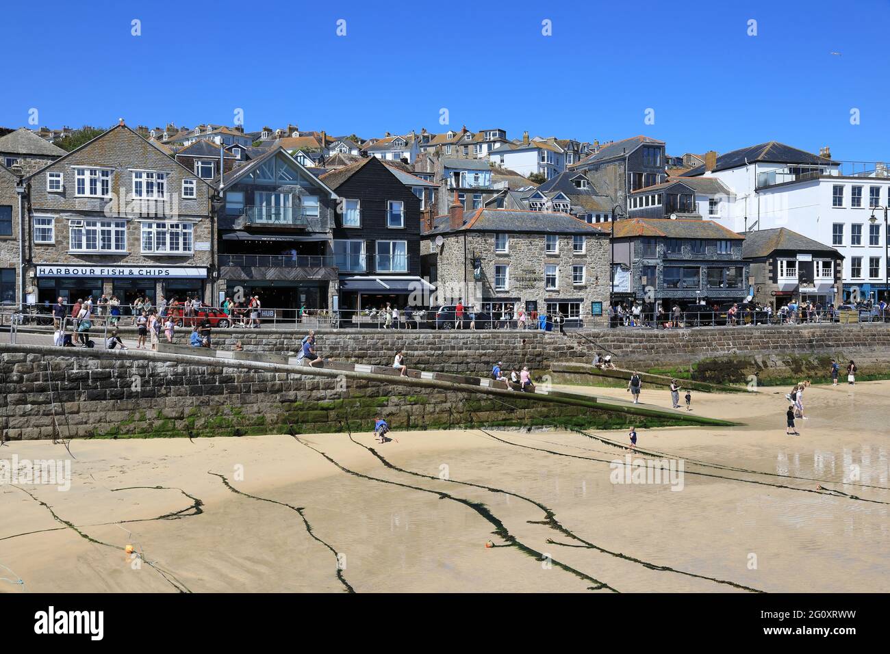 Restaurants and pubs lining the harbour in pretty St Ives, in Cornwall ...