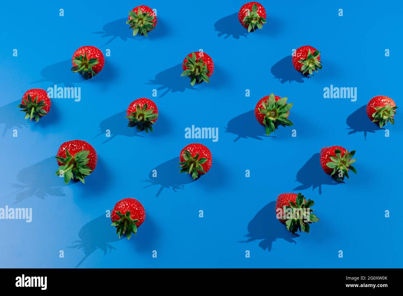Red strawberries on blue background. Ripe tasty berry Stock Photo - Alamy