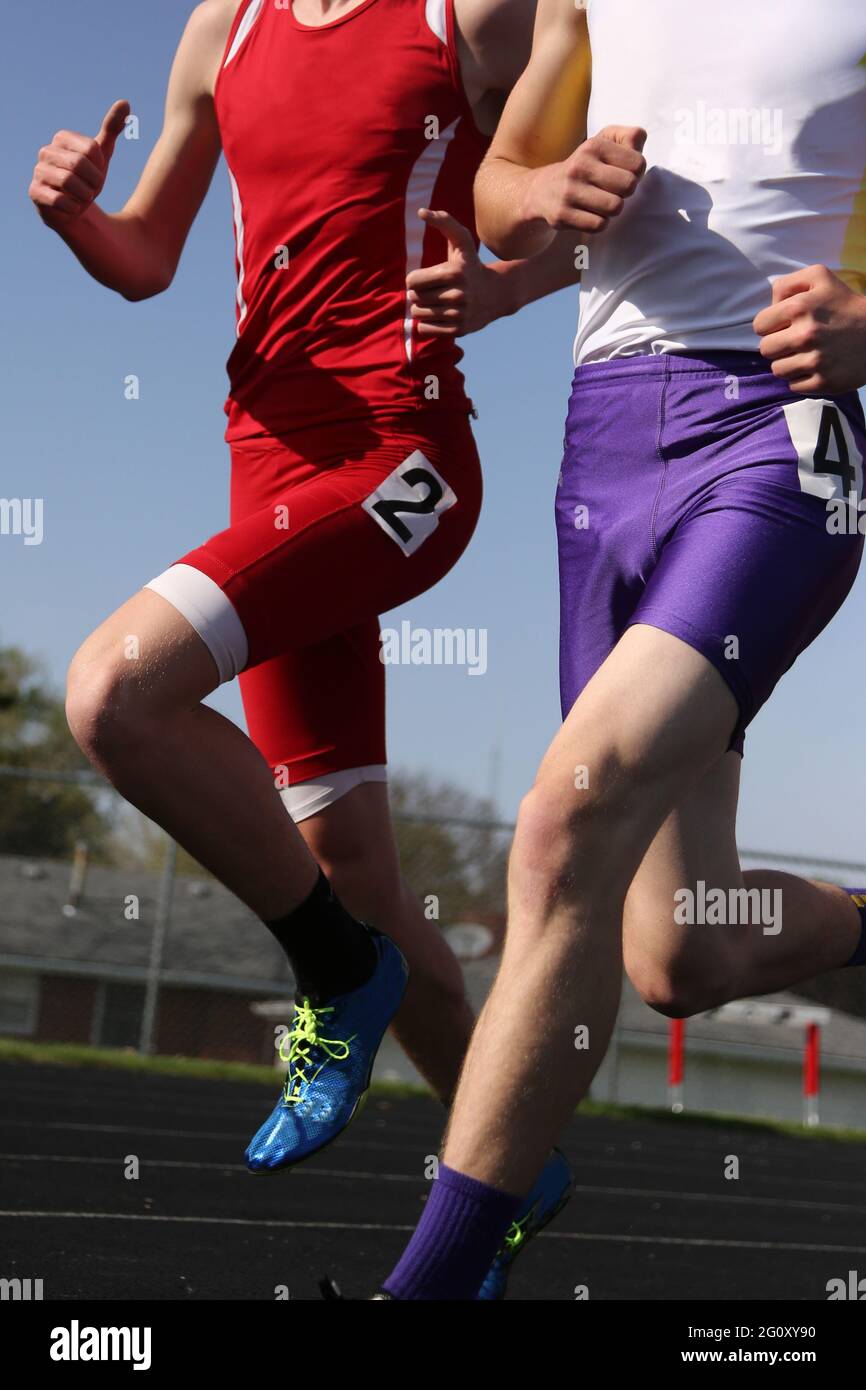 Two track athletes run side-by-side while running in a distance event ...