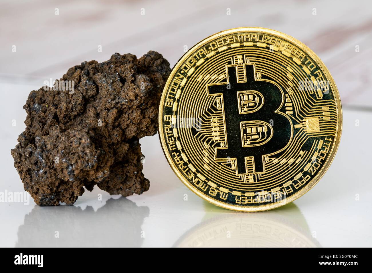 Bitcoin token made in gold with a volcanic rock symbolizing the mining ...