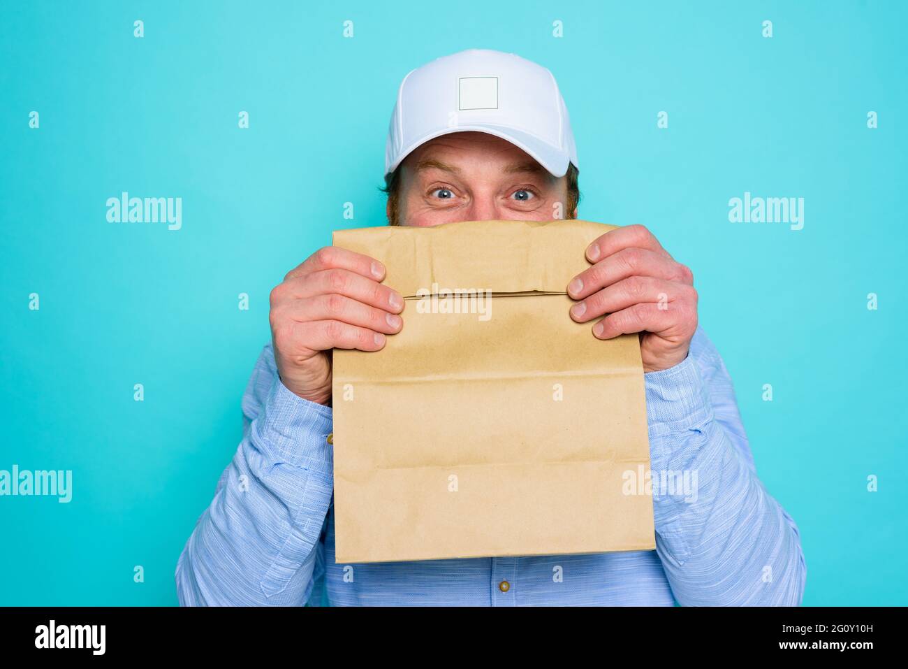 Delivery man hides his face with a food package Stock Photo - Alamy
