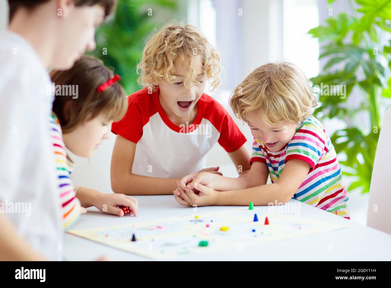 Family playing board game at home. Kids play strategic game. Little boy ...