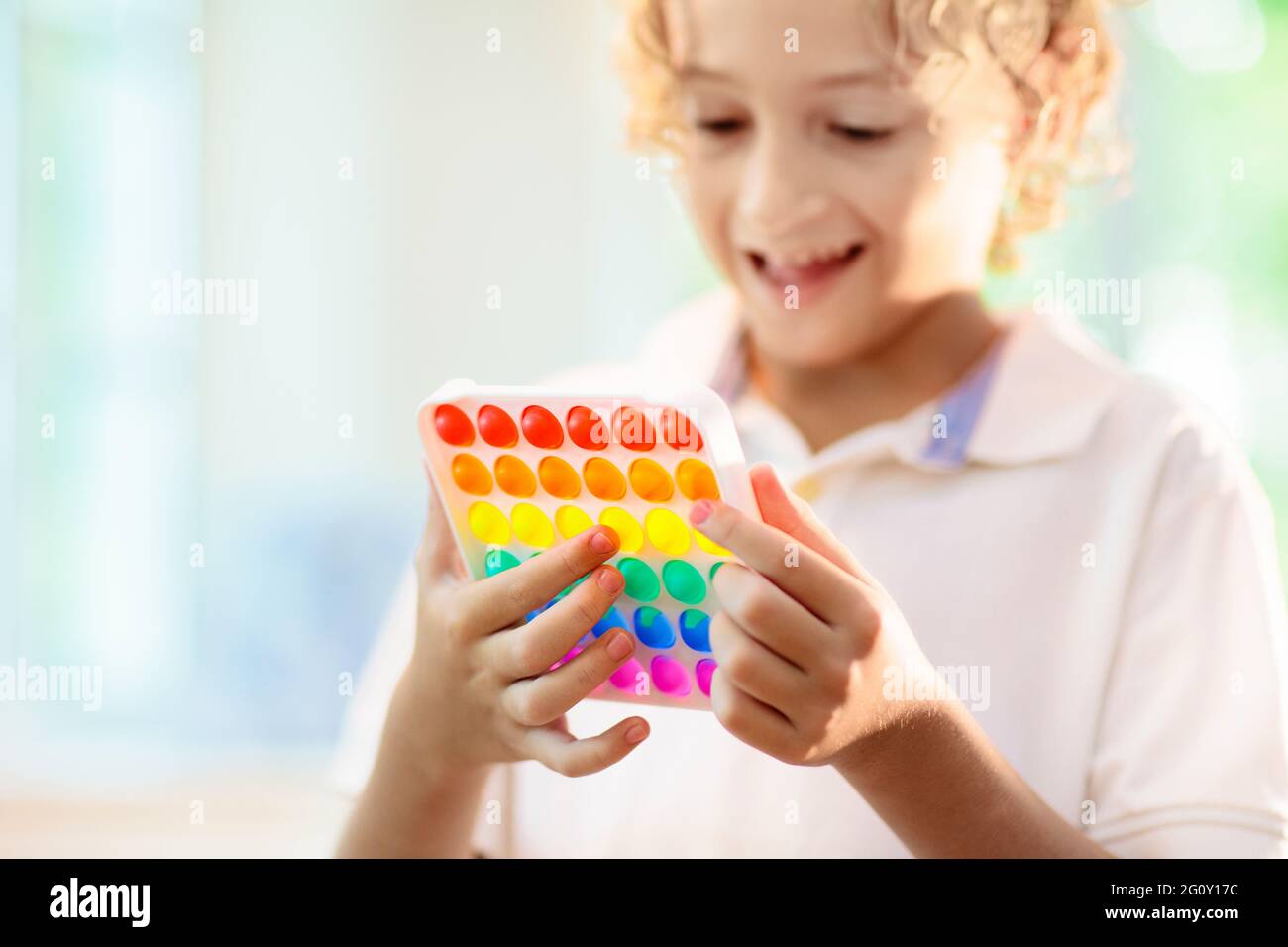 Kids play with pop it sensory toy. Stress and anxiety relief. Trendy ...