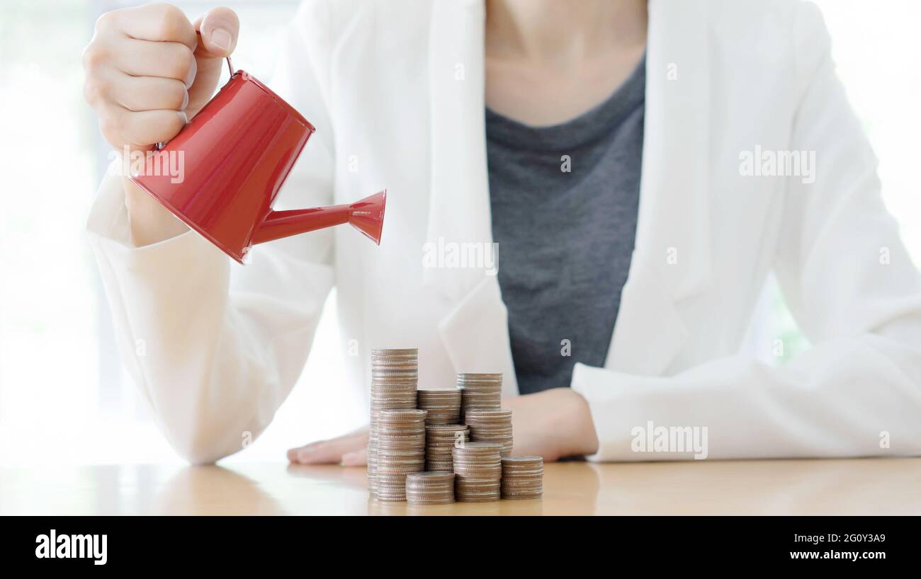 hand business woman and red watering can with money Stock Photo - Alamy