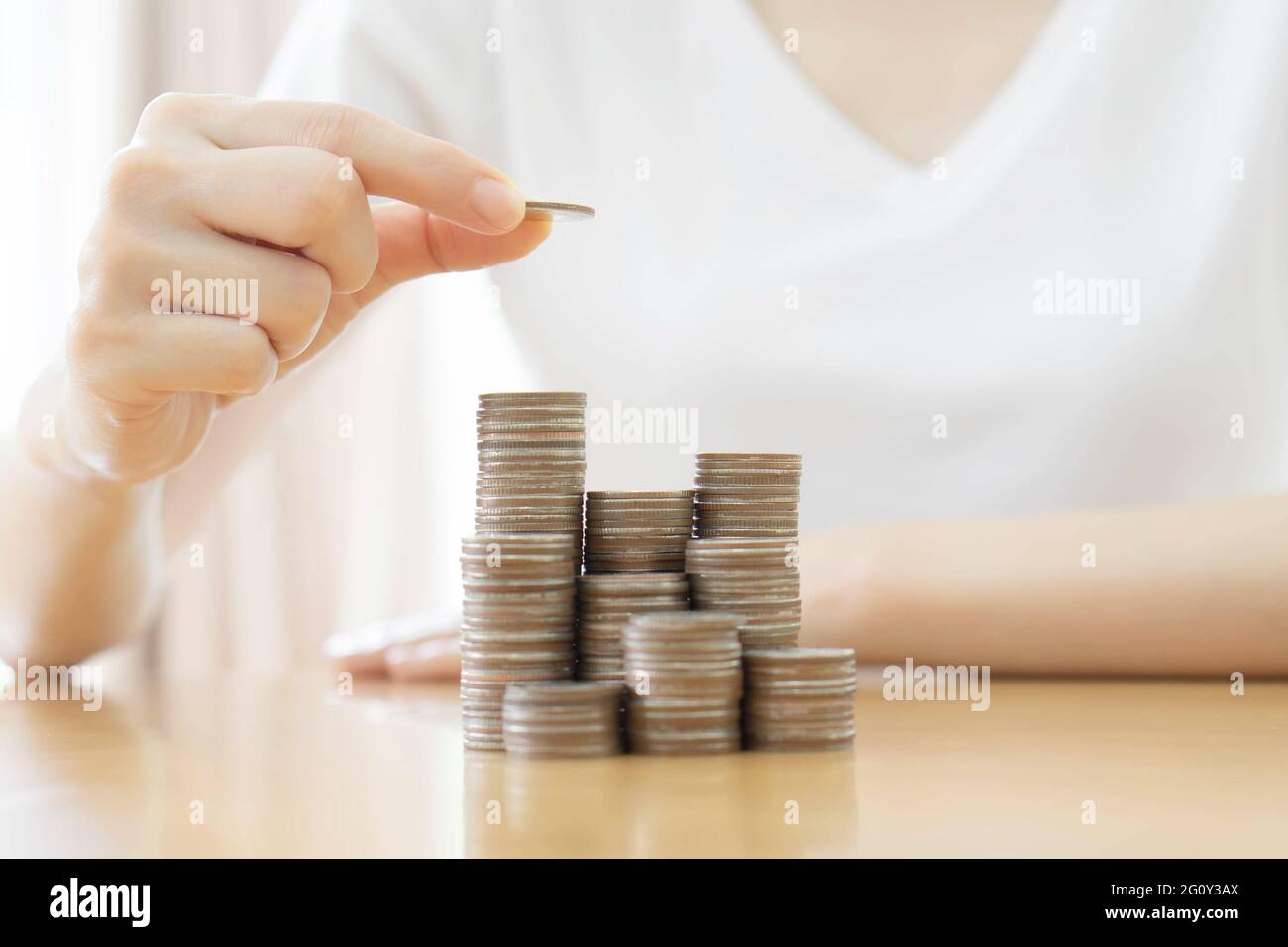 Hand put coins to stack of coins on white background Stock Photo - Alamy