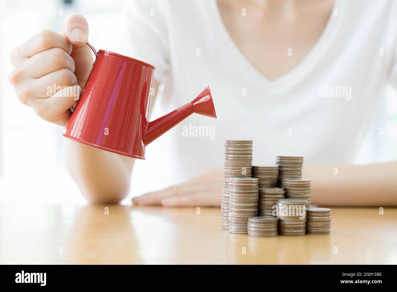 hand business woman and red watering can with money Stock Photo - Alamy