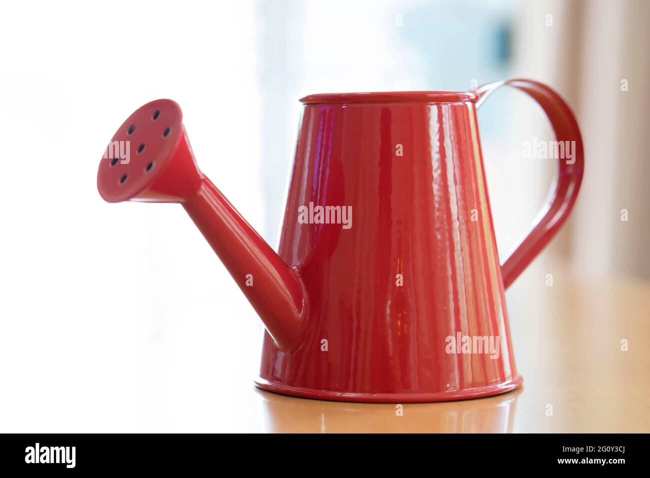 A red watering can isolated on white background Stock Photo - Alamy