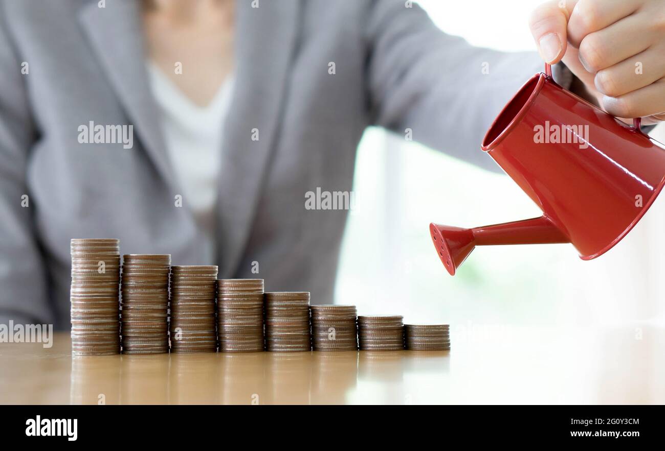 hand business woman and red watering can with money Stock Photo - Alamy