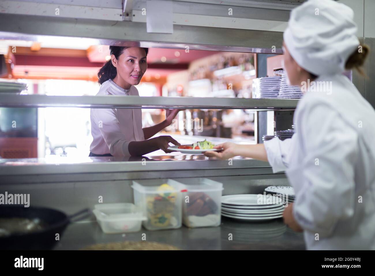 female waitress geting order from female chef in cafe Stock Photo - Alamy