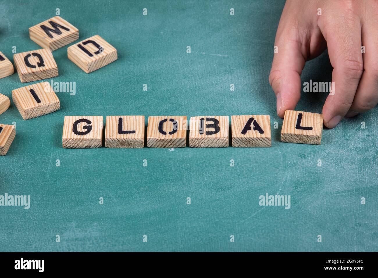 GLOBAL. Wooden alphabet letters on a green blackboard background Stock ...