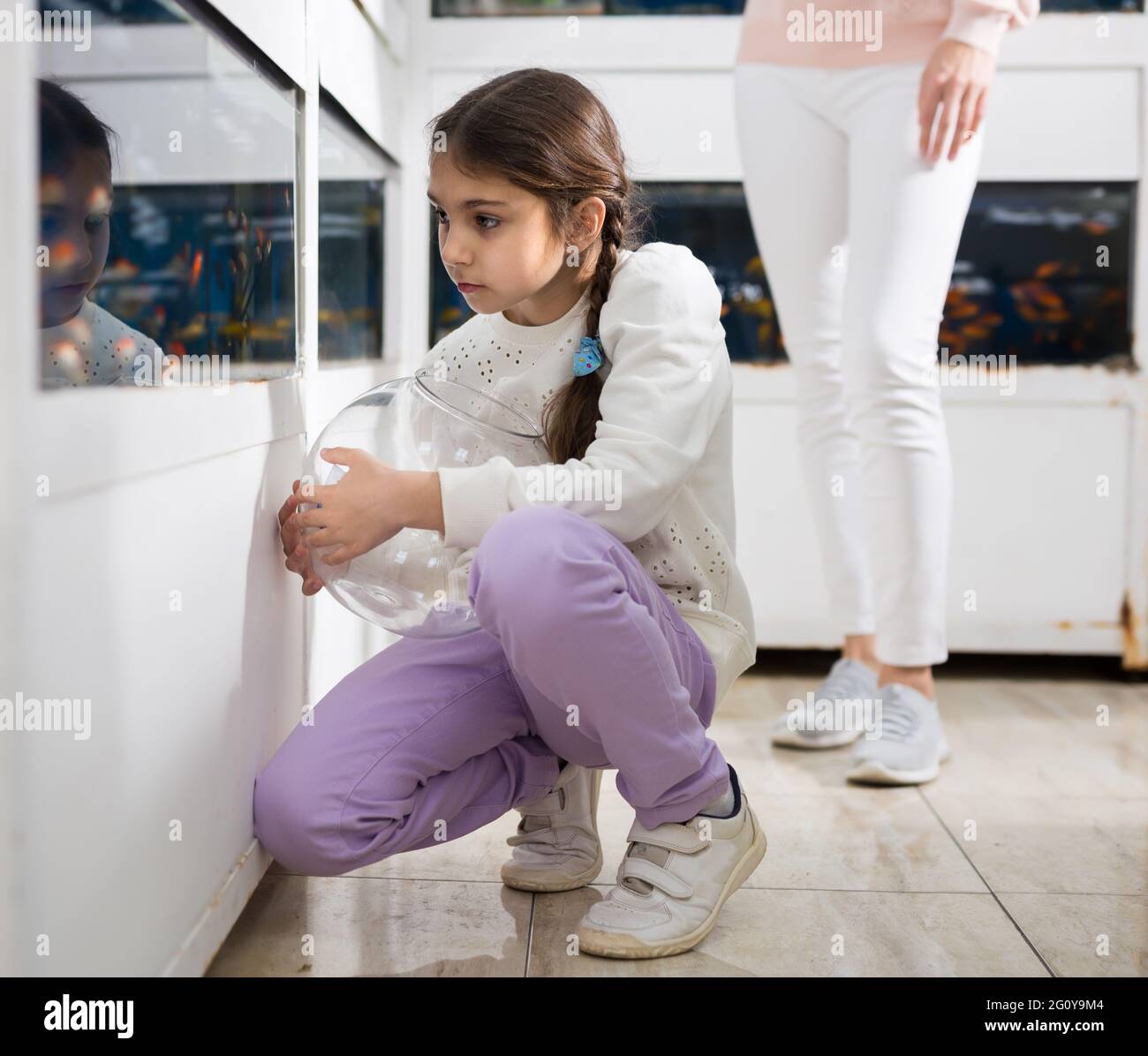 Portrait of kid girl looking for new fish for small home aquarium Stock ...