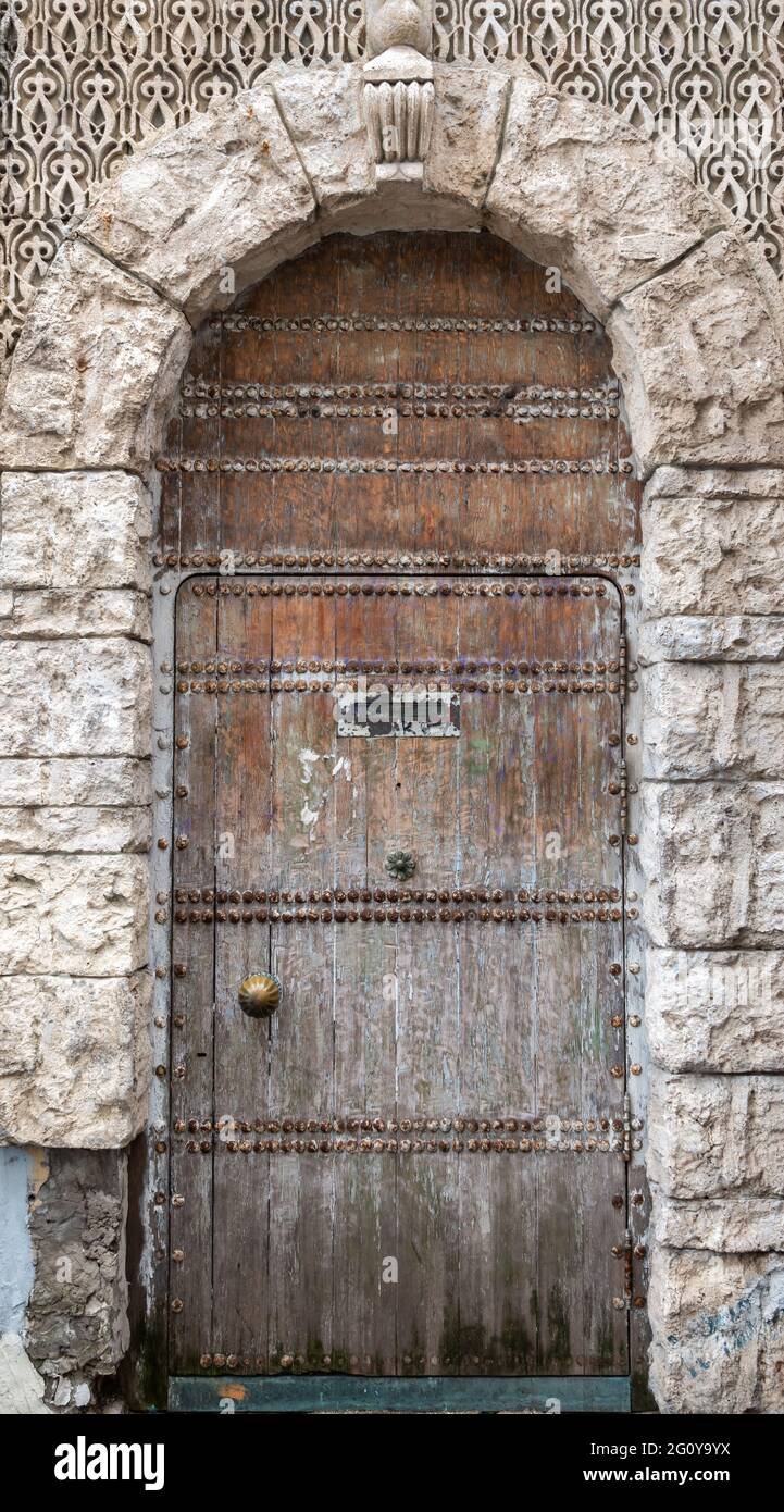Ancient stone wall with a gate in the old castle. Wooden gate of a ...