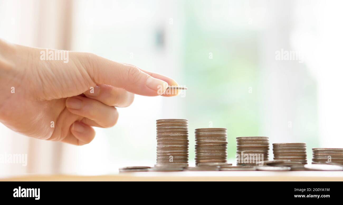 woman put coins to stack of coins Stock Photo - Alamy