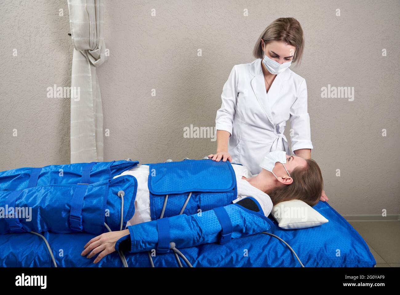 woman receiving the procedure of pressure therapy to make her legs ...