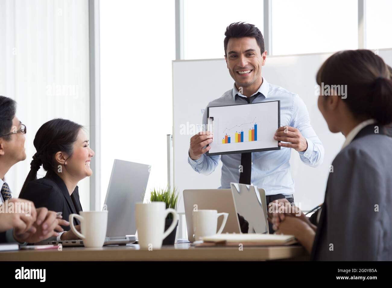 Business executive delivering a presentation to his colleagues during ...
