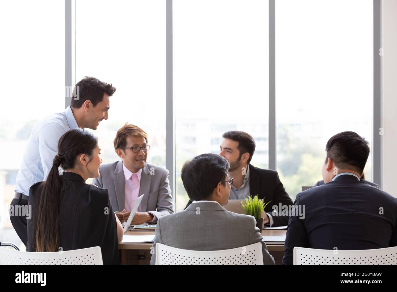 Chief businessman standing at conference table during team meeting ...