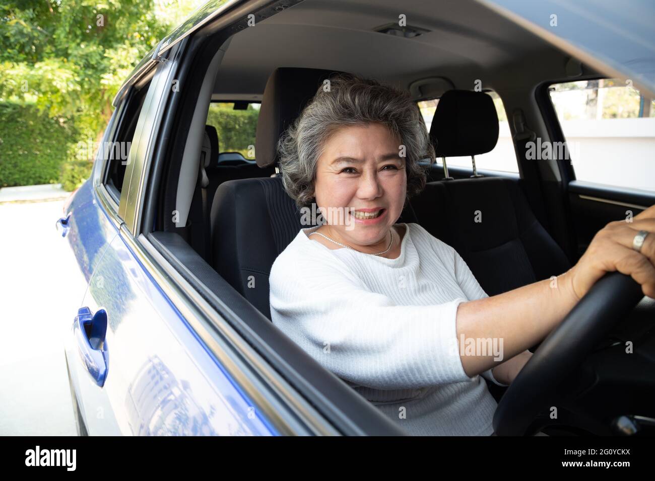 Asian senior woman driving a car and smile happily with glad positive ...