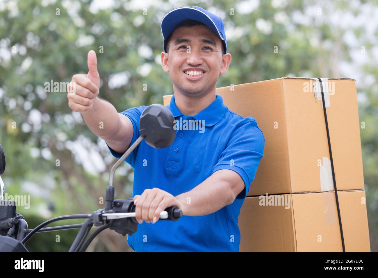 Delivery man send order parcel with motors and thumb up Stock Photo - Alamy