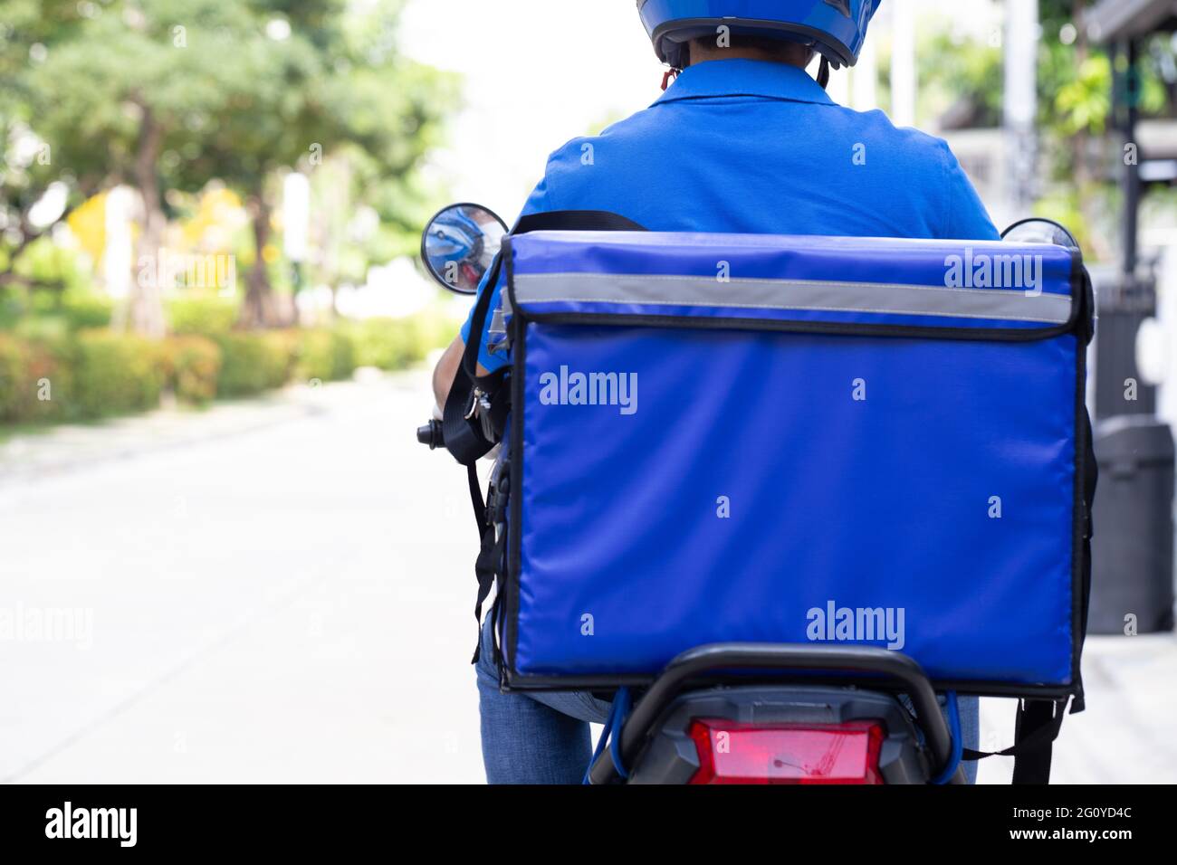 Delivery man wearing blue uniform riding motorcycle and delivery box ...