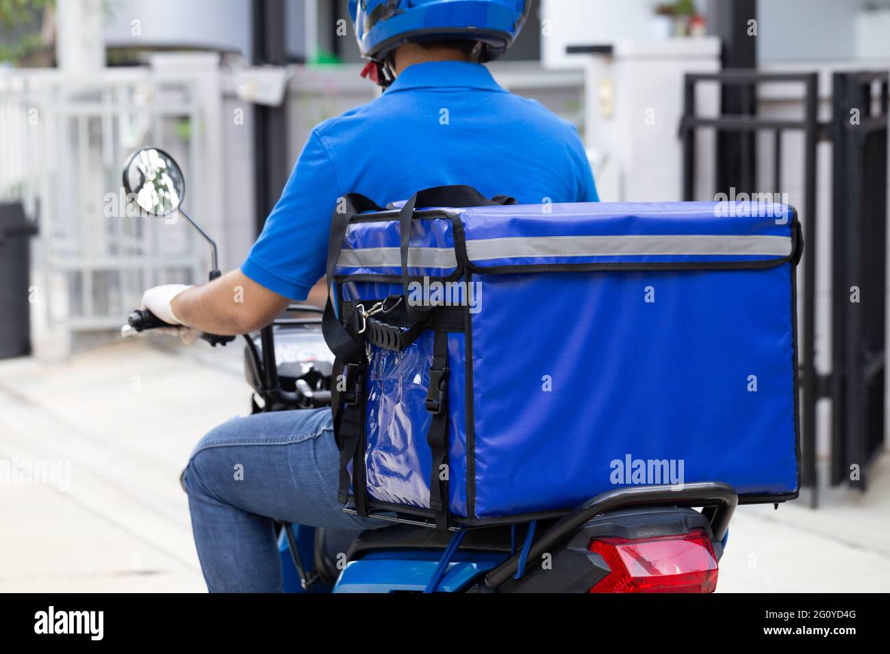 Delivery man wearing blue uniform riding motorcycle and delivery box ...