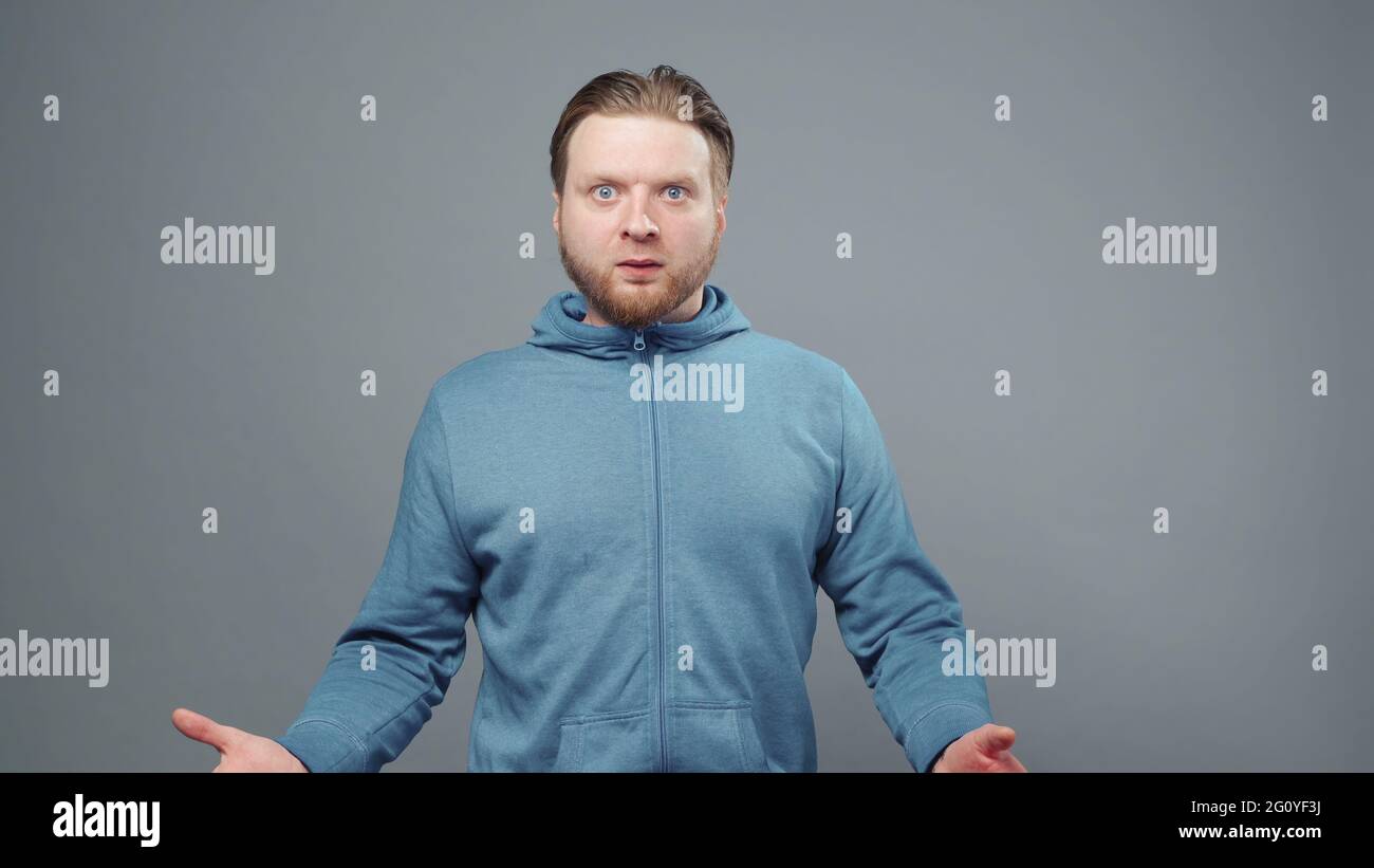 Photo of surprised young man in blue sweatshirt Stock Photo - Alamy
