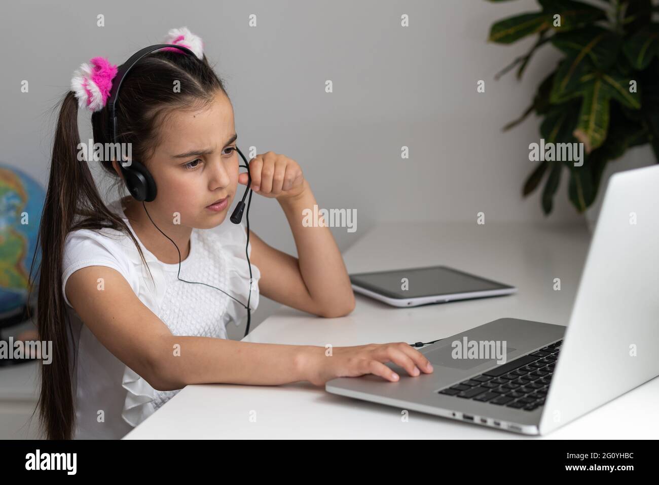 A young girl is attending online school or classes. Study in lock down ...