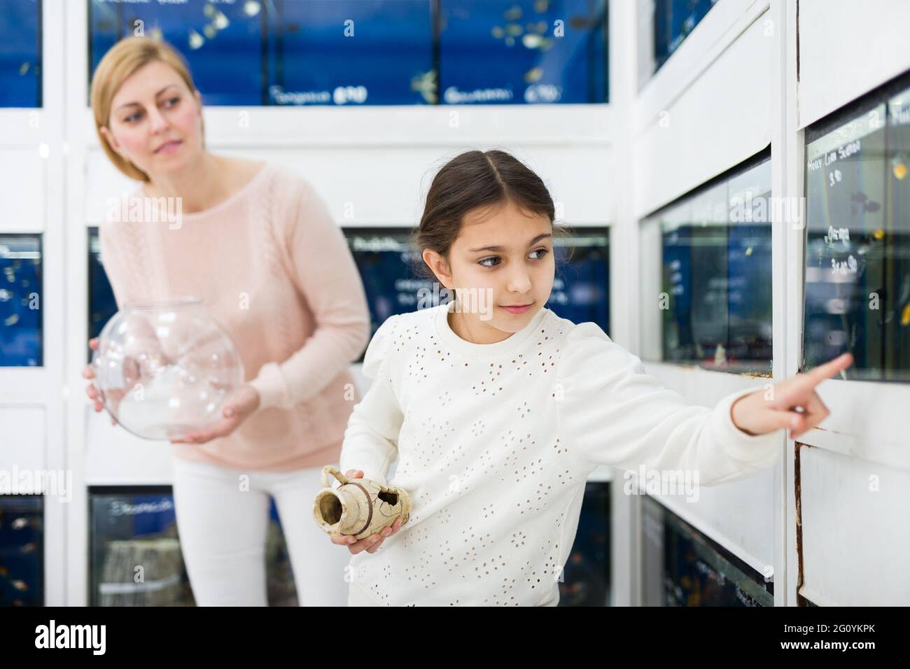 Cute girl with her mother customer buying tropical fish Stock Photo - Alamy