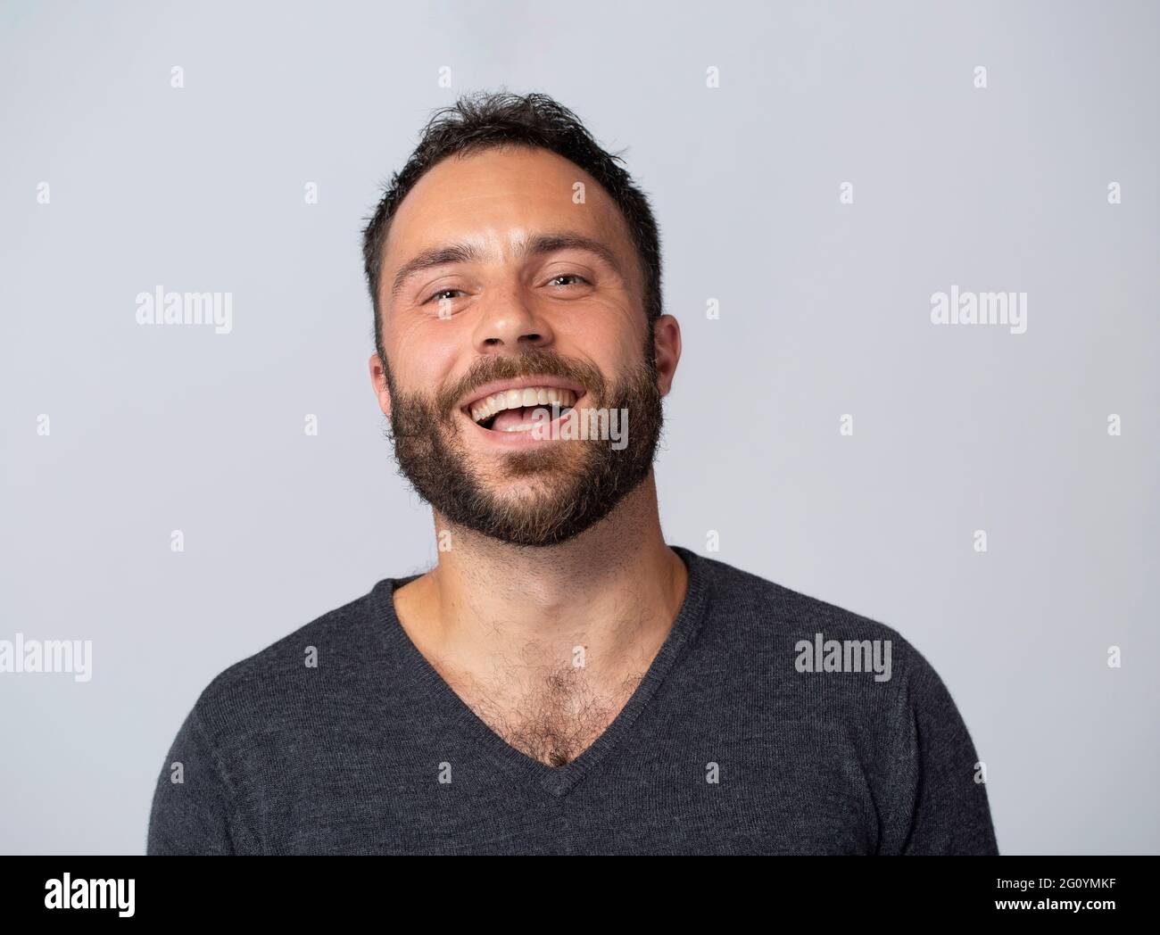 Mature contented man with beard smiling on white background with gray ...