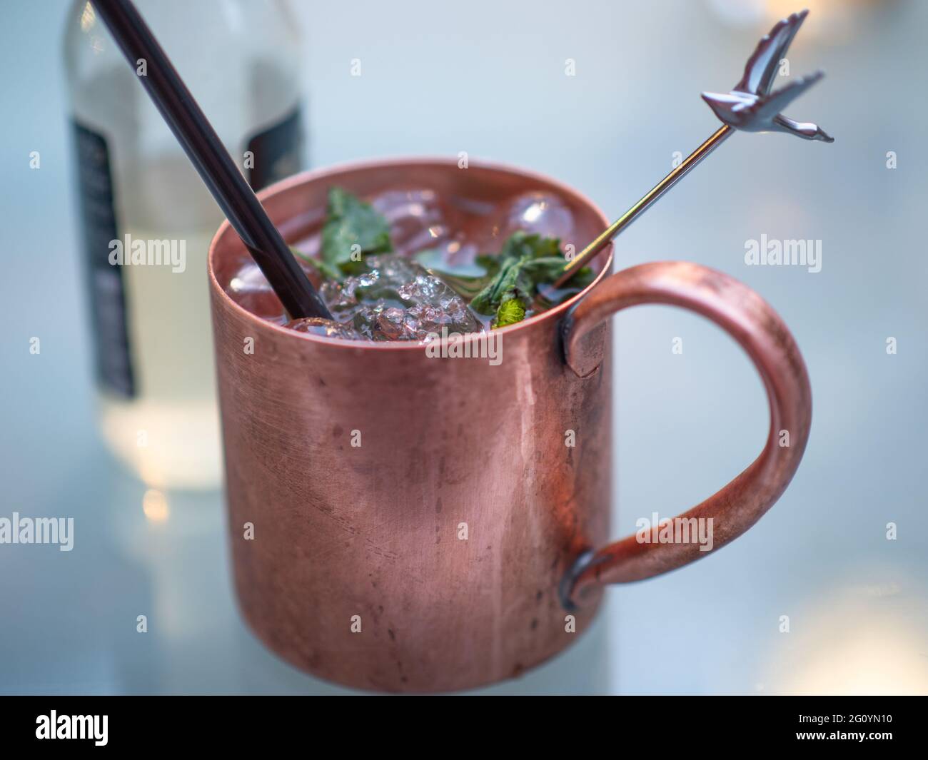 Iced Moscow mule in a copper mug and bottle of ginger beer Stock Photo ...