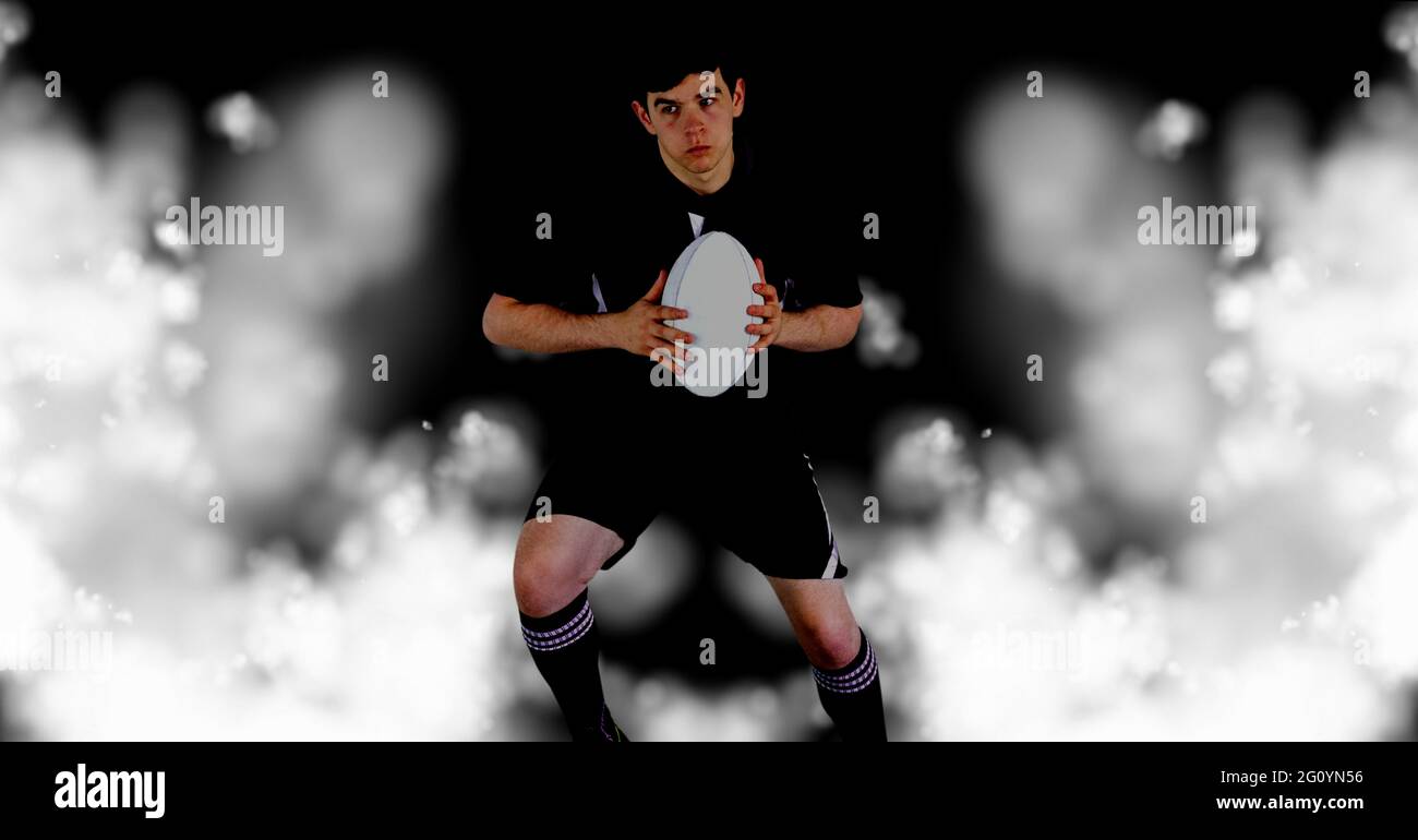 Compostion of caucasian rugby player holding ball on black background ...
