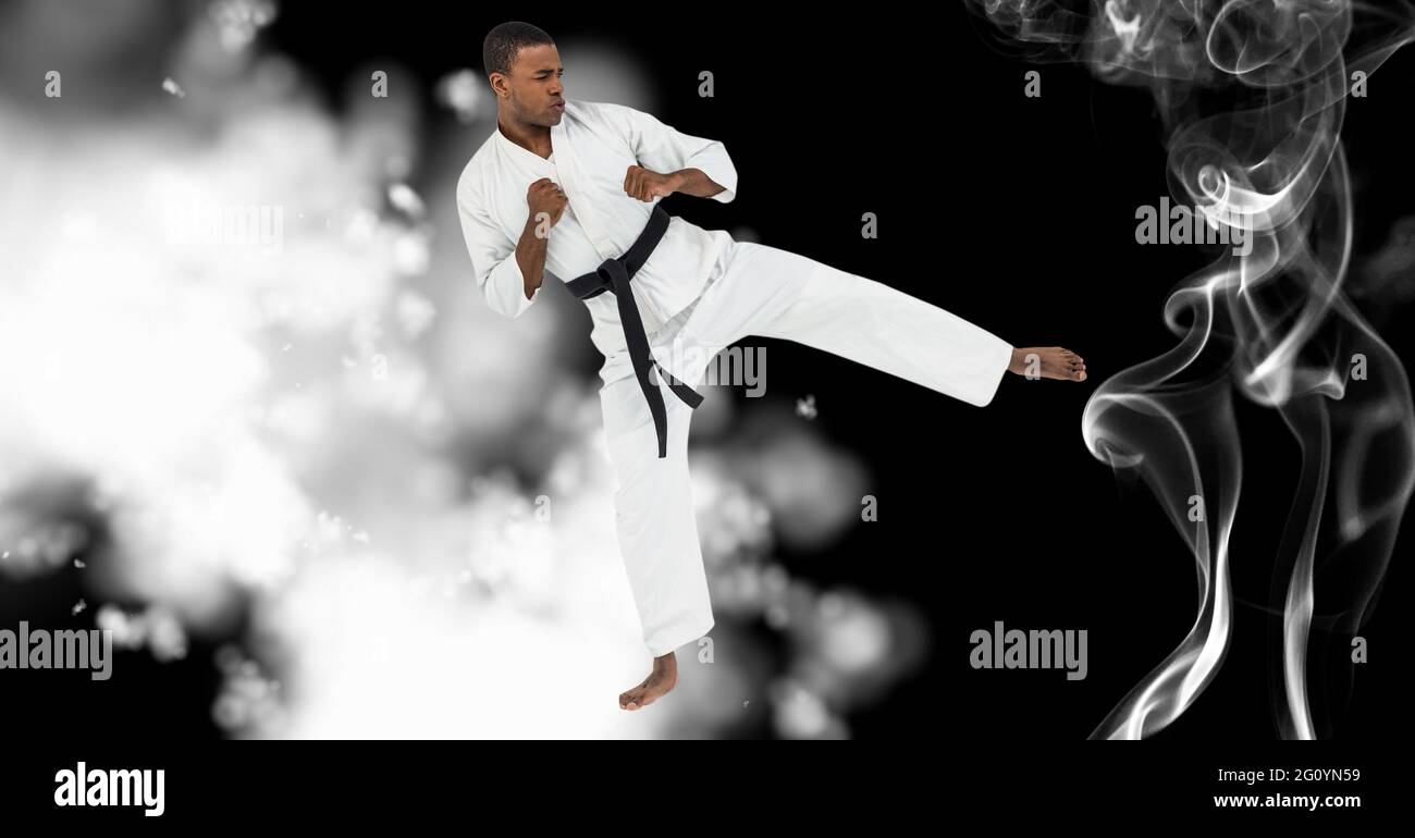 Compostion of african american male karate fighter on black background ...