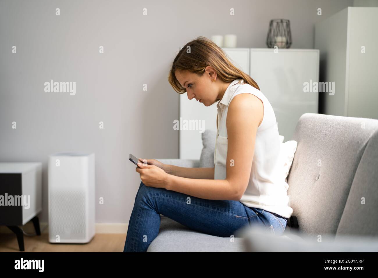 Woman With Neck Pain Sitting Using Mobile Phone Stock Photo - Alamy