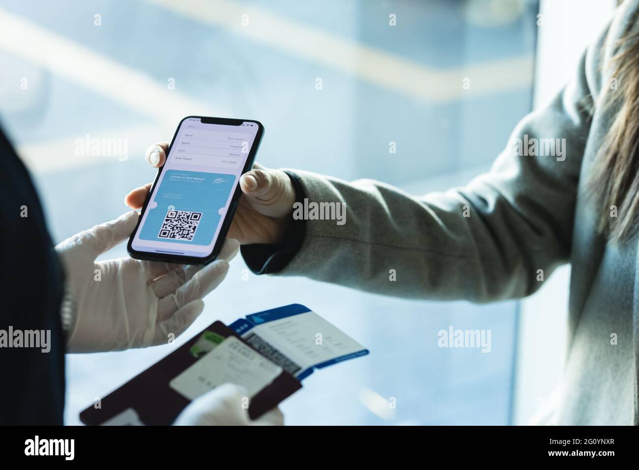 Passenger showing digital medical pass on her mobile to ground ...
