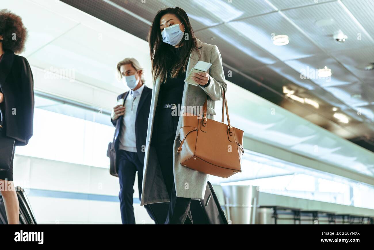 People wearing face masks and keeping social distance while walking ...