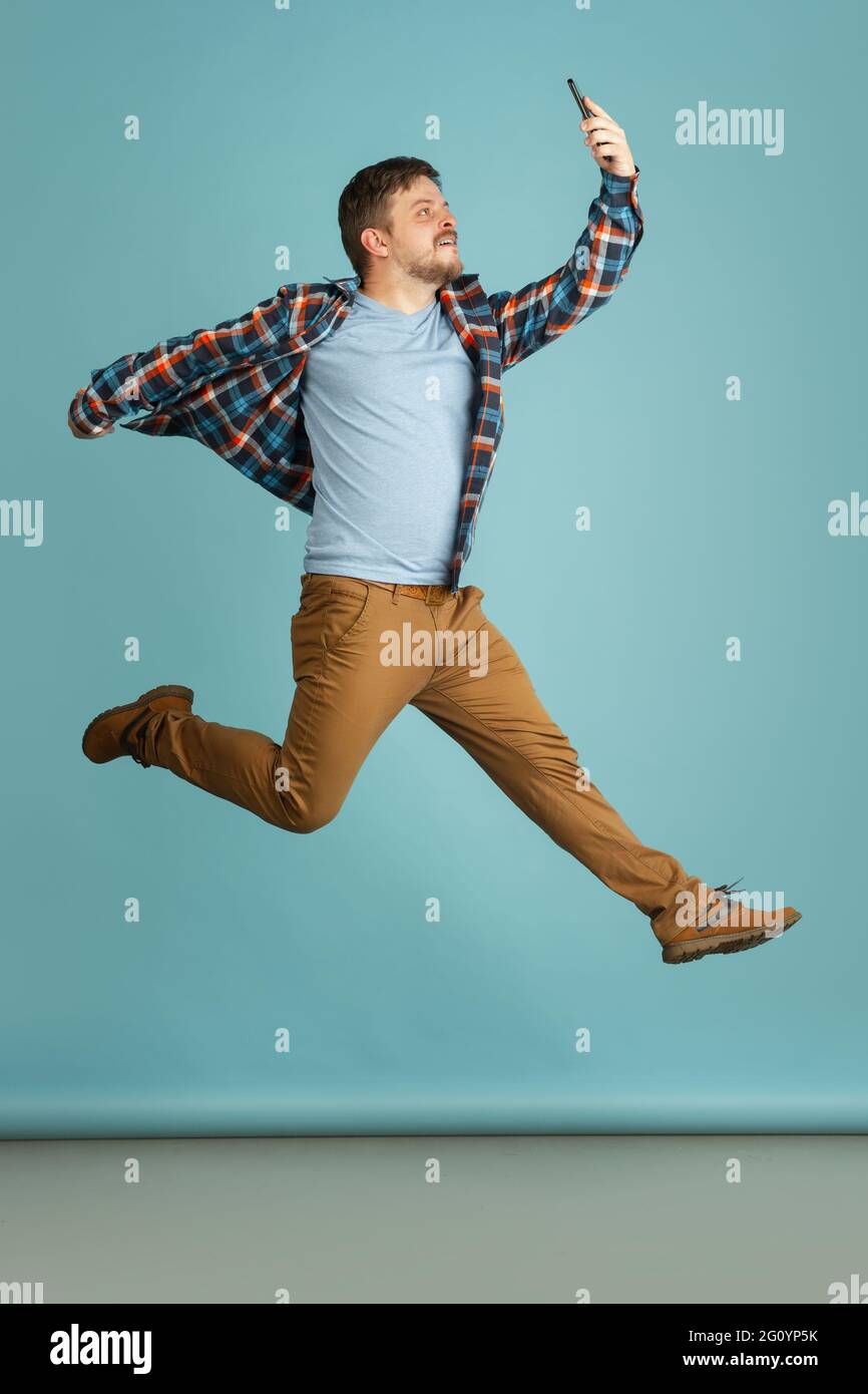Young happy Caucasian bearded man in casual clothes jumping isolated on ...