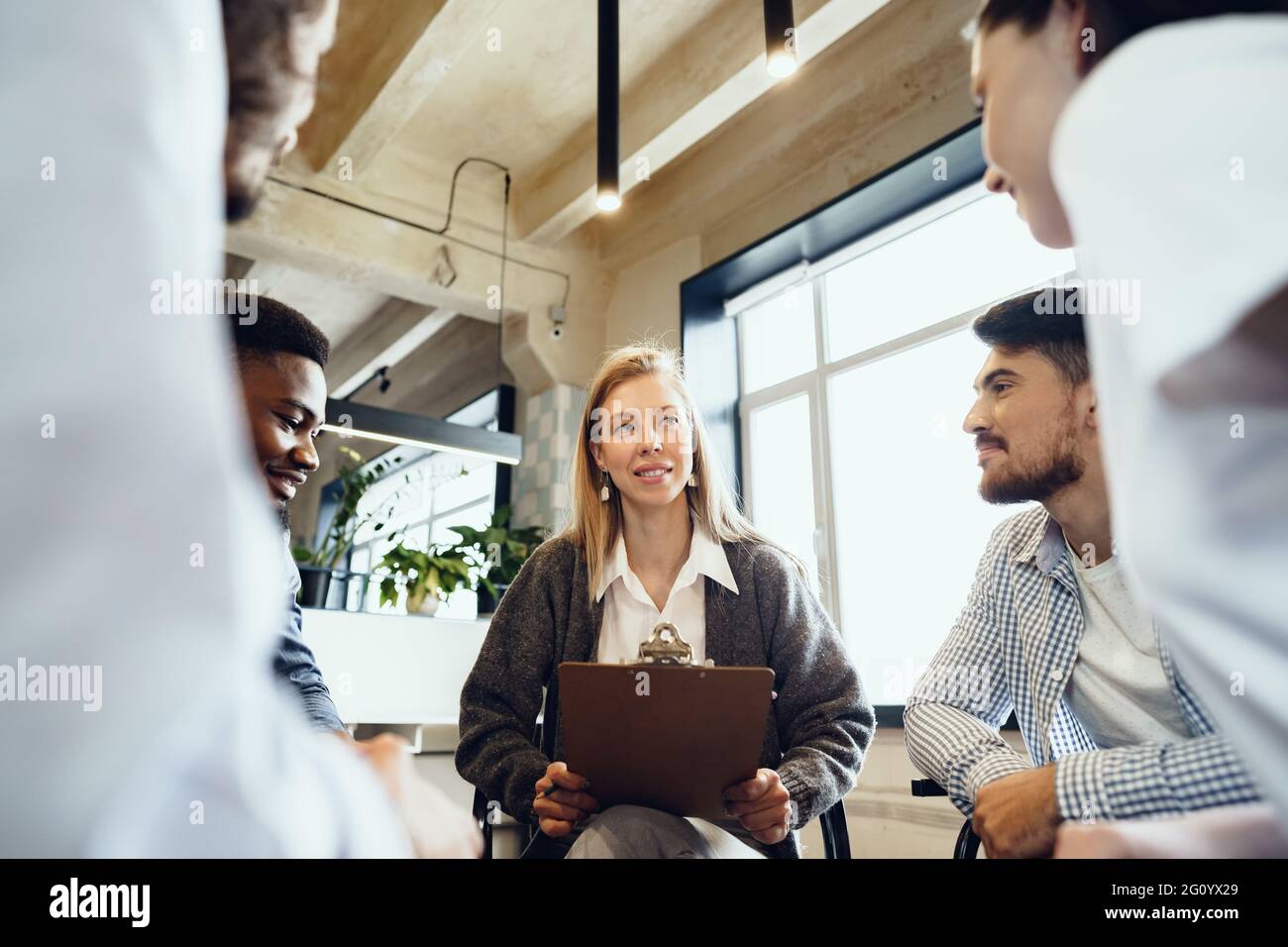 Young people sitting in a circle and having a discussion Stock Photo ...
