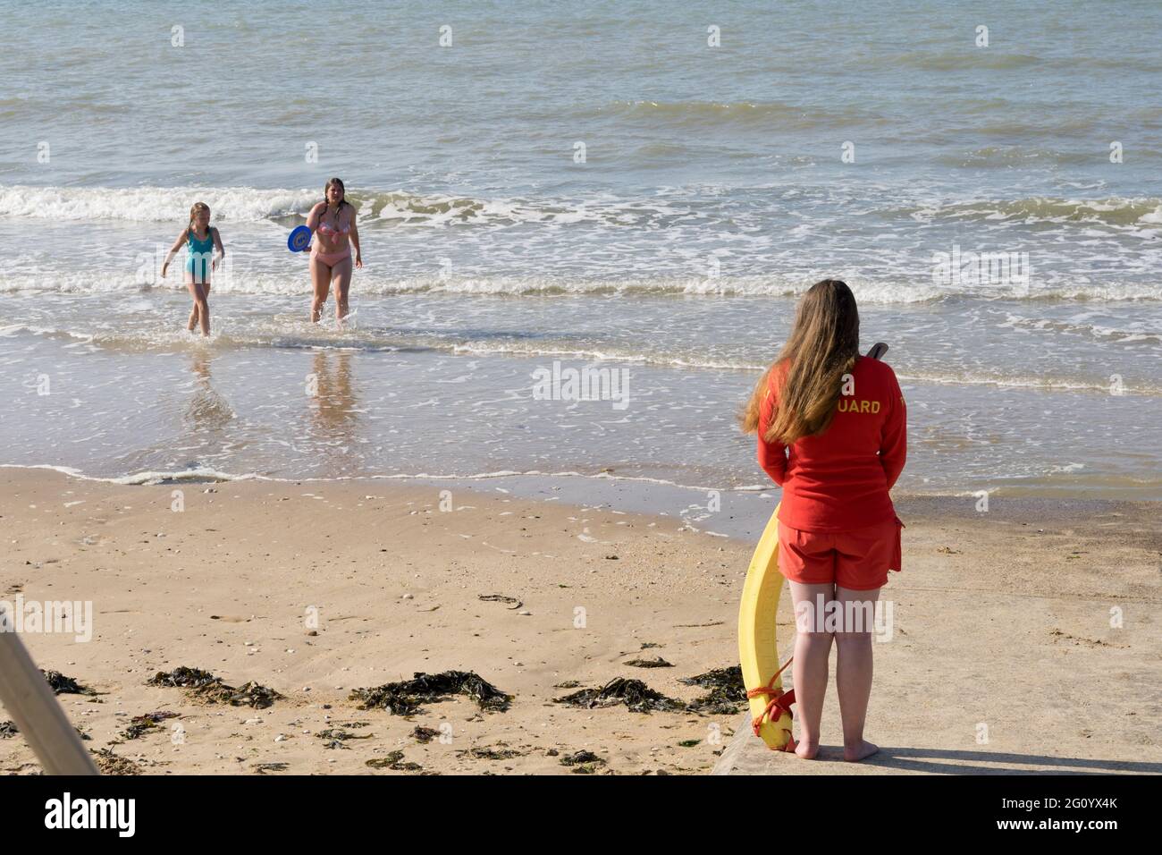RNLI lifeguard staff on sea front keeps an eye on swimmers in the sea ...