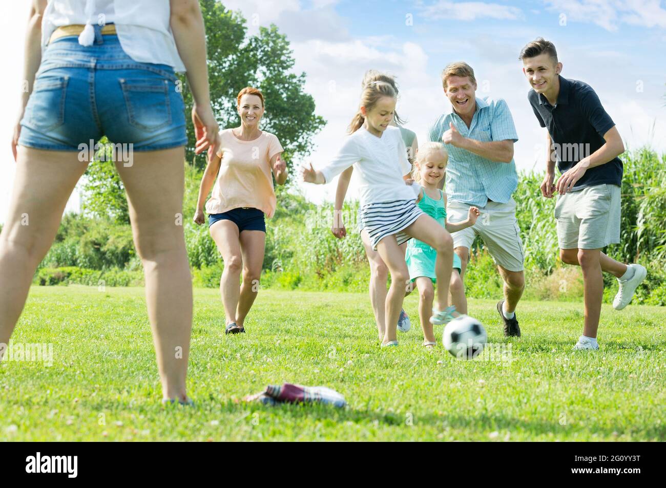 Family with four kids running after ball Stock Photo - Alamy