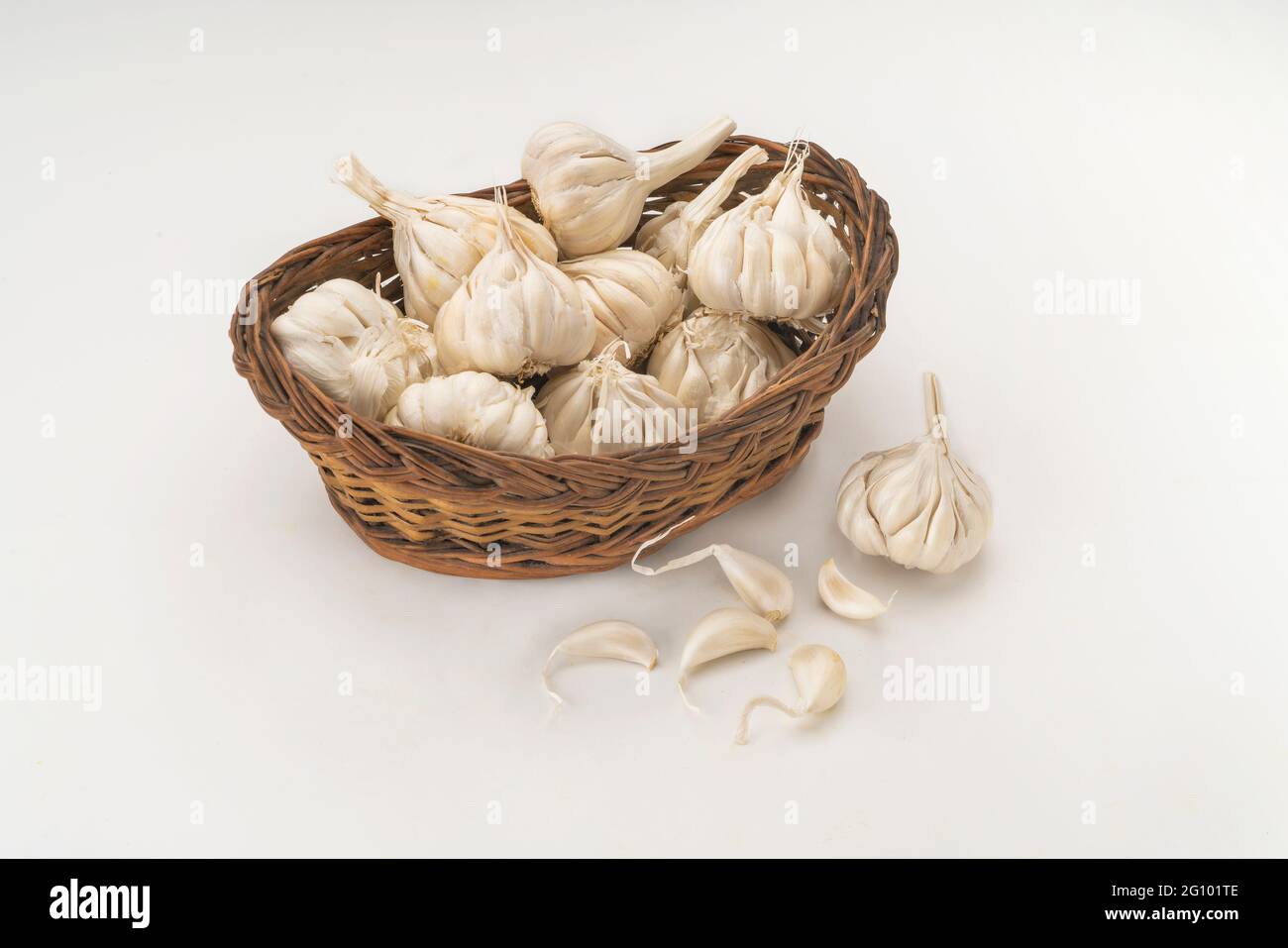 Closeup top view of dried garlic bulbs arranged in cane basket with ...