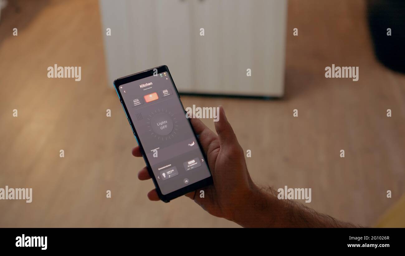 Close up of man using voice activated application to turn on bulbs in ...