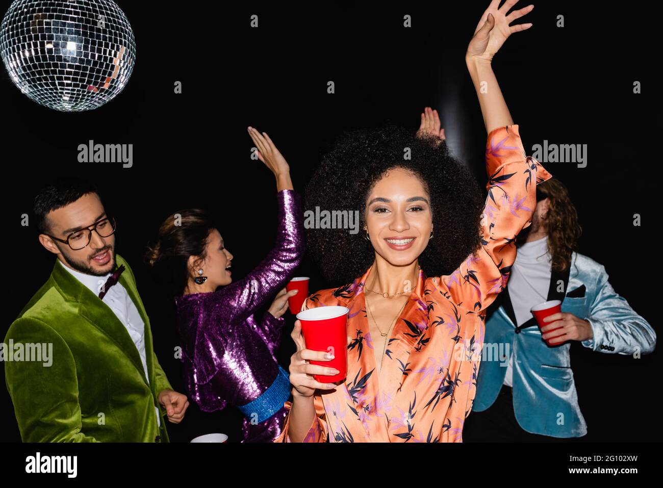 positive african american woman dancing on party with multiracial ...