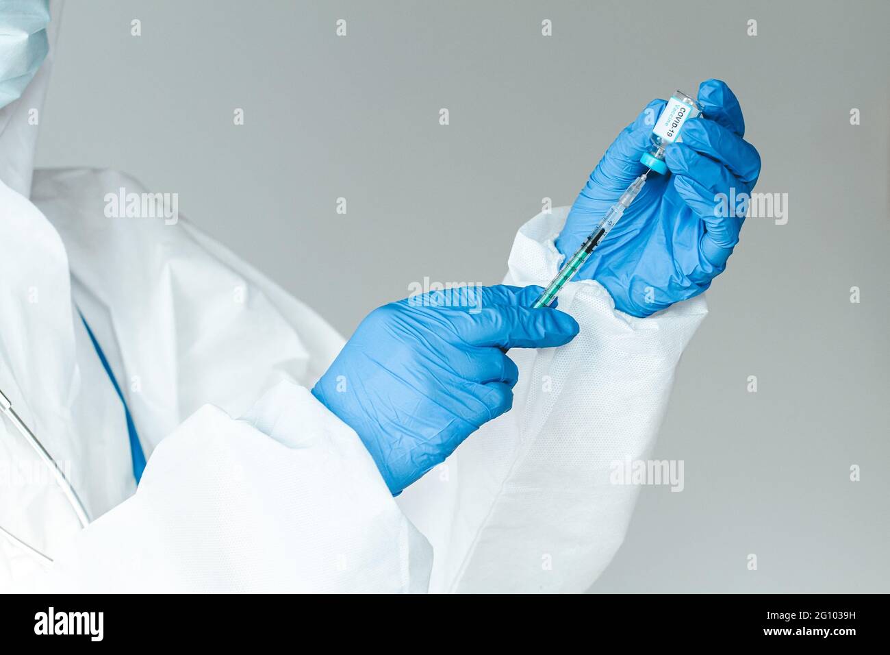 Doctor or nurse in a protective suit holds a syringe and covid 1 Stock ...