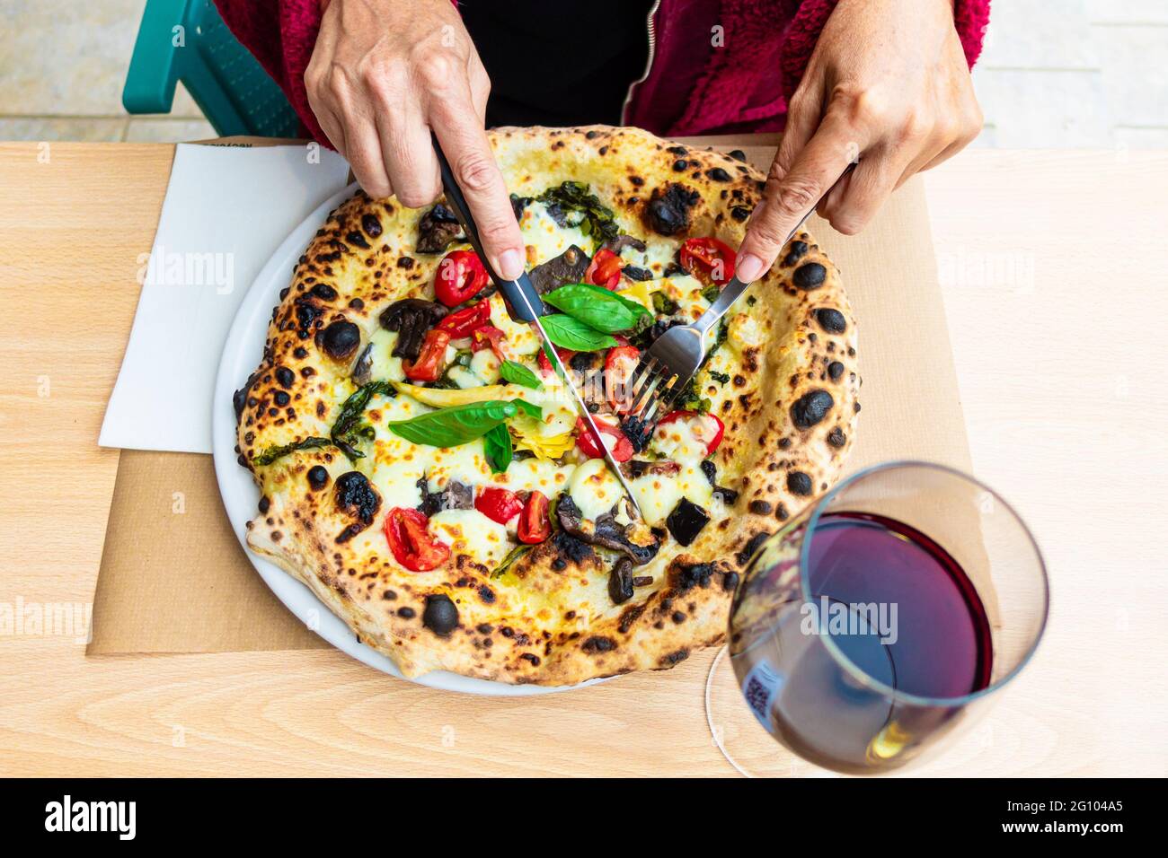 Closeup hand of woman cutting pizza at restaurant pizzeria. Female ...