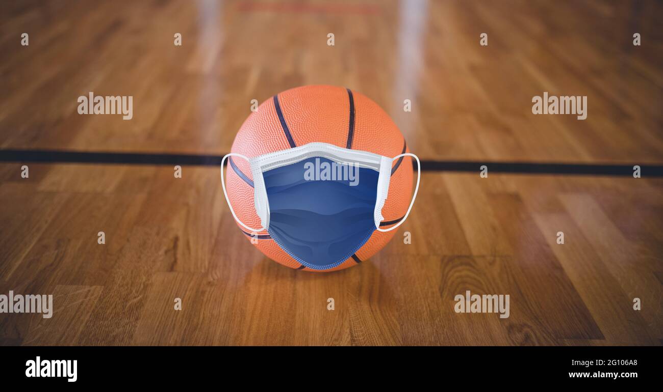 Composition of basketball with face mask on basketball court with copy ...