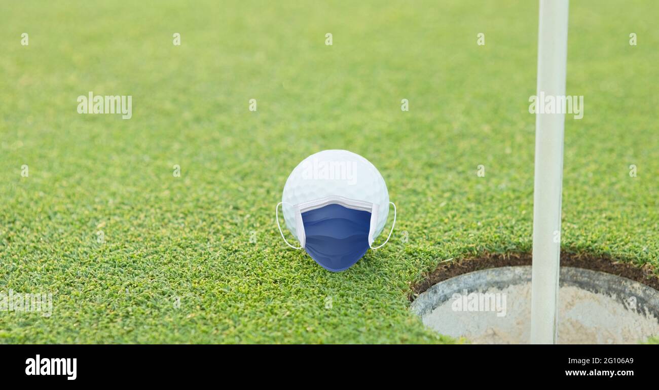 Composition of golf ball with face mask on grass with copy space Stock ...
